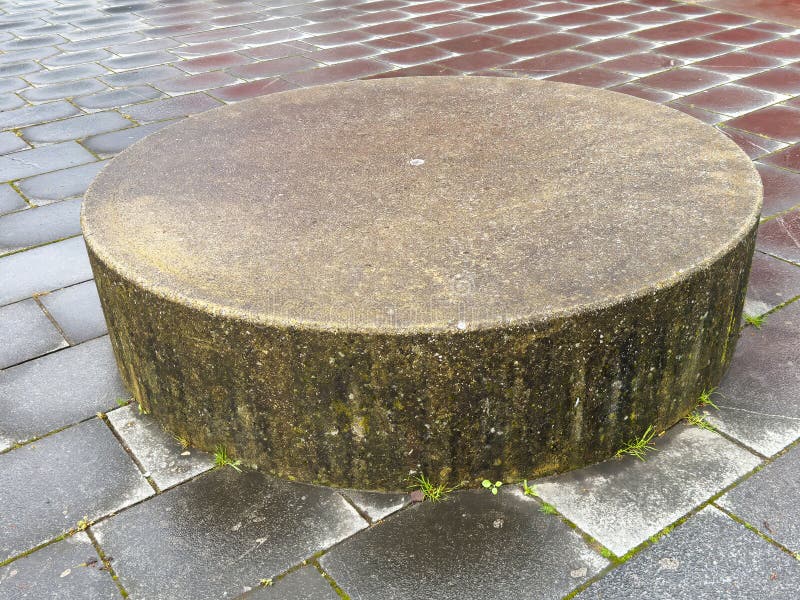 Round Stone Pedestal on Paved Street with Moss and Grass Growth ...