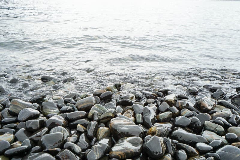 Round Stones at Seashore with Sea Waves Stock Image - Image of gray ...