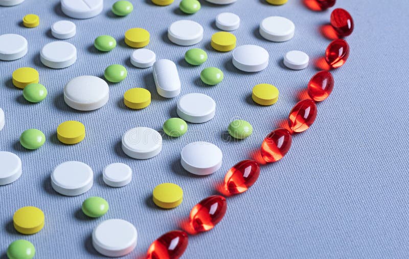 Round Tablets of Different Sizes with Red Capsules. Pharmaceutical ...