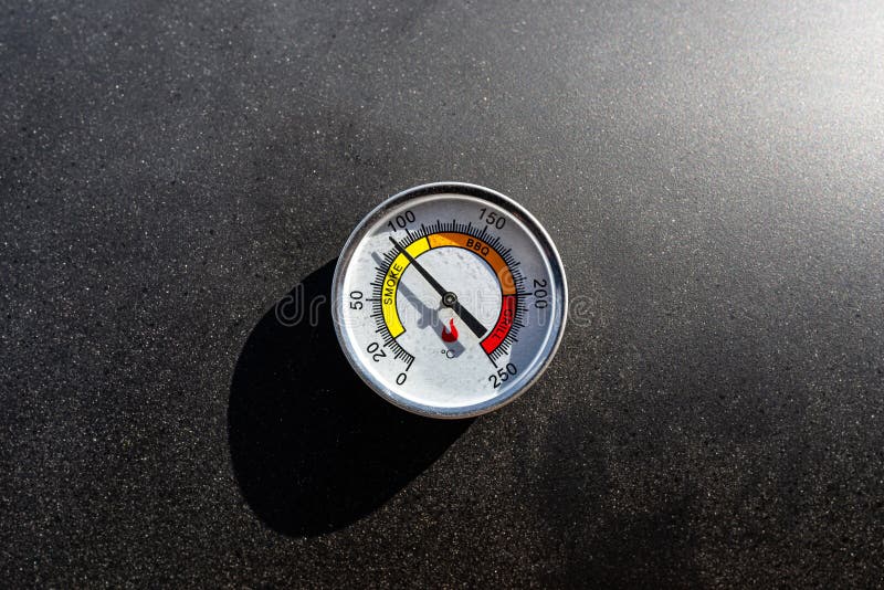 A Round Thermometer Showing 90 Degrees Celsius Placed on a Charcoal ...