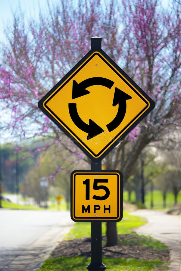 Roundabout Sign in Front of a Budding Tree Stock Image - Image of pink ...