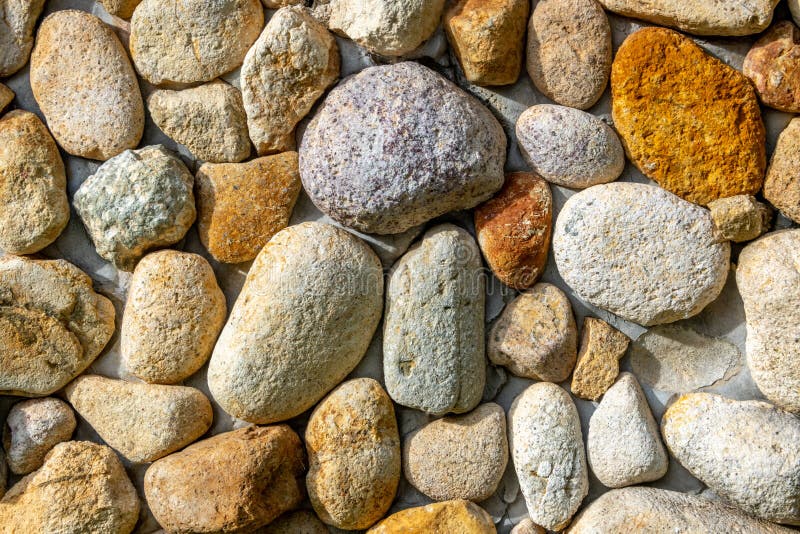 Rounded Pebbles Embedded in a Concrete Wall Stock Photo - Image of ...