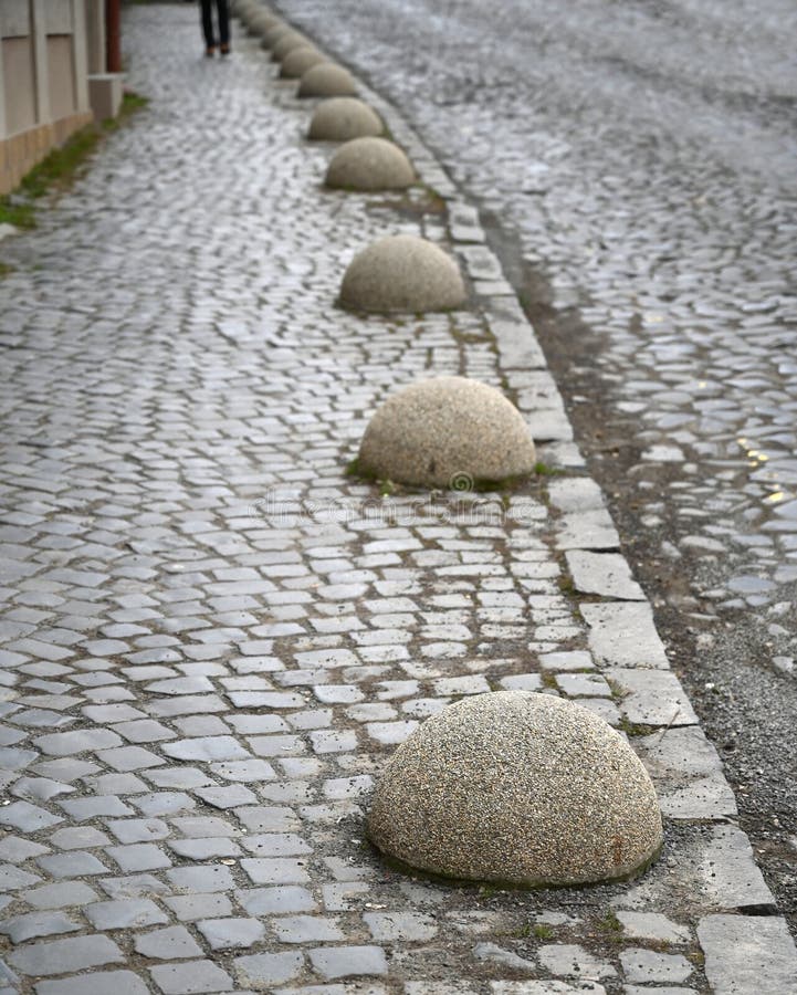 Rounded Stone Barriers Lining a Cobblestone Street Stock Image - Image ...