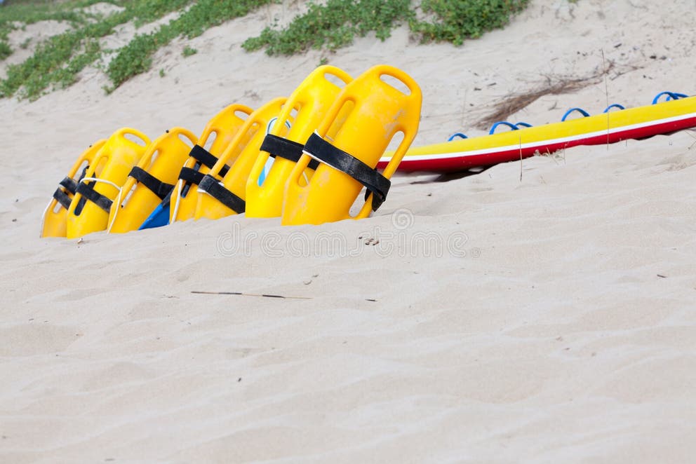 Row of Bright Yellow Floatation Devices on Beach Stock Photo - Image of ...