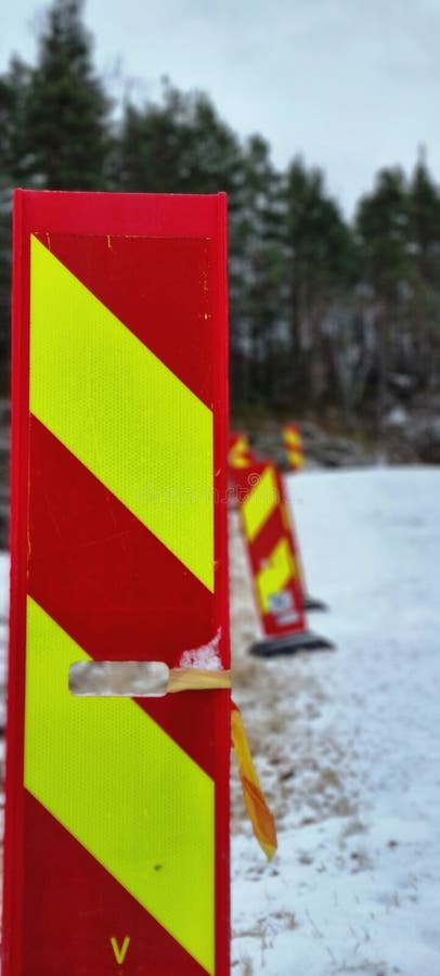Row of Bright Red and Yellow Signs on the Side of a Snow Covered Forest ...