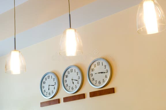 Row of Clocks Showing Different Time and Lamps Stock Photo - Image of ...