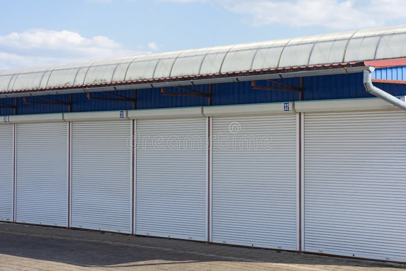 A Row of Closed Market Stalls with White Shutters with Blue Sky Stock ...