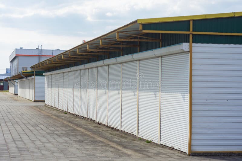 A Row of Closed Market Stalls with White Shutters with Blue Sky Stock ...