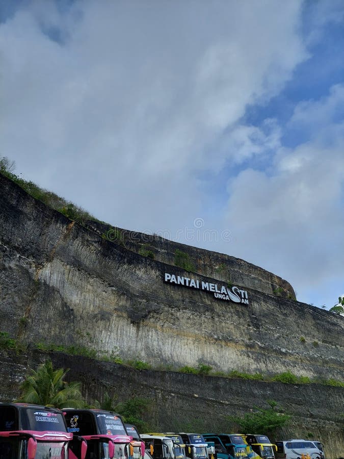 A Row of Colorful Buses Parked Under a Dramatic Cliff Editorial Stock ...