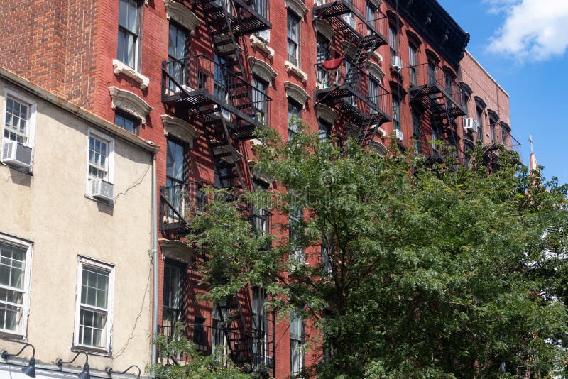 Row Of Colorful Old Brick Residential Buildings With Fire Escapes In