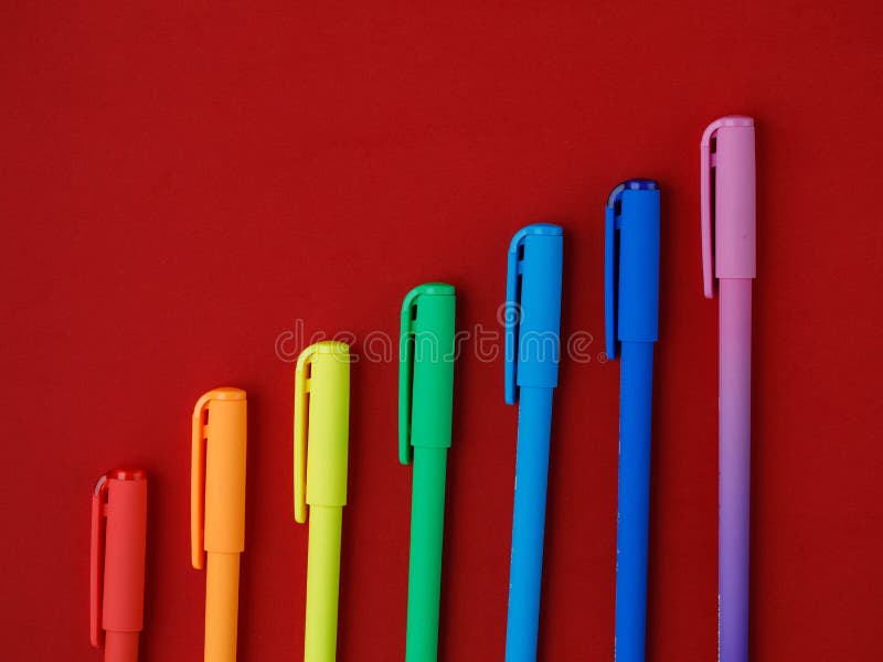 The Row of Colorful Rainbow Pens Lying on Bright Red Paper Background ...