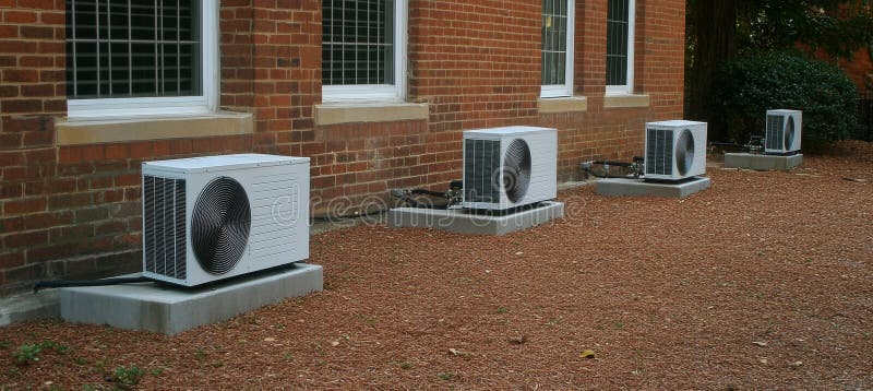 Row of Five Outdoor Air Conditioner Units Installed Outside a Brick ...