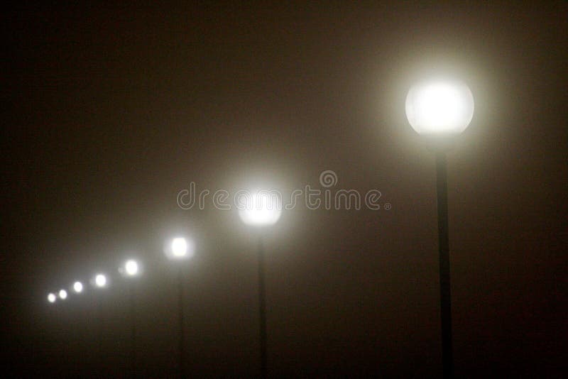 Row of Lamp Posts Glowing in the Dark Stock Image - Image of ...