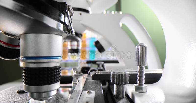 Row of Microscopes and Test Tubes with Colored Liquid in Laboratory ...