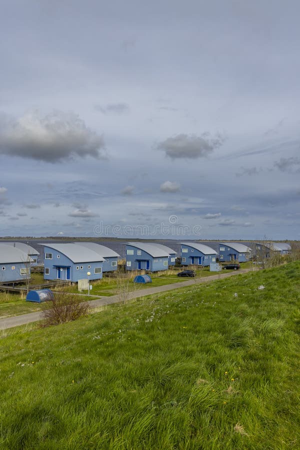Row of Modern Blue Bungalows Facing the River Under Cloudy Sky Stock ...