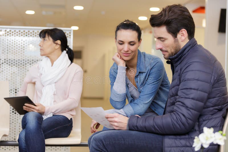 Row People Sitting Side by Side while Waiting Stock Photo - Image of ...