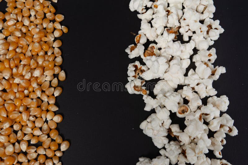 A Row of Ready-made Popcorn and a Row of Corn Kernels on a Black ...
