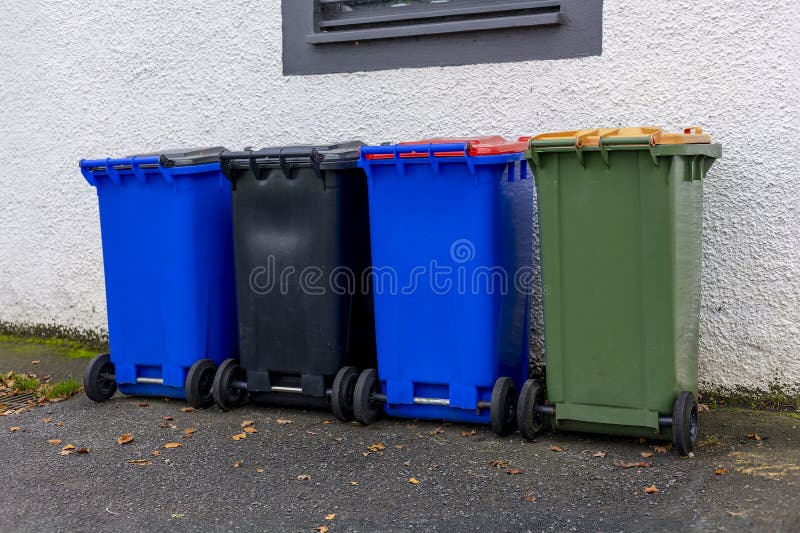 Row of Recycling Wheelie Bins with Wheels beside White Wall Stock Photo ...