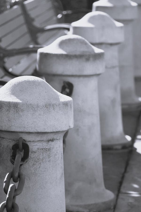 Row of Short Round-top Flared Cement Posts Linked with Large Chains ...