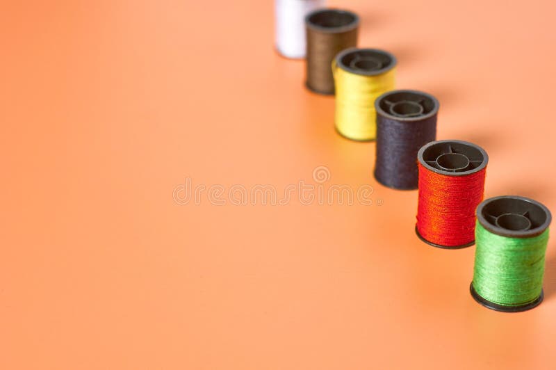 Row of Spools with Colorful Threads on Orange Tailors Desk in Workshop ...