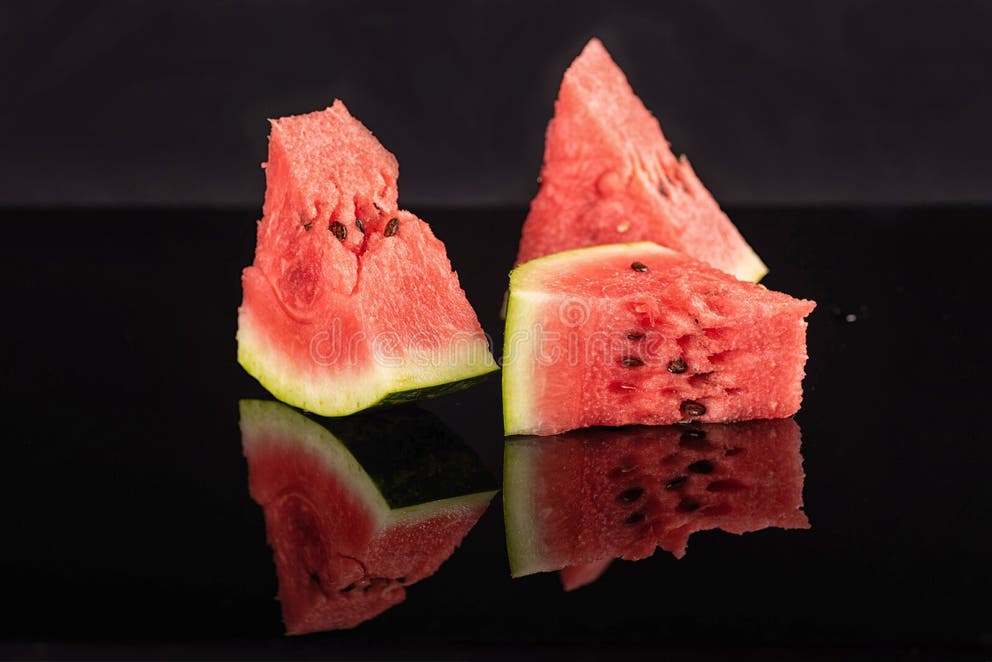 Row of Three Watermelon Slices on Black Reflective Surface Stock Photo ...