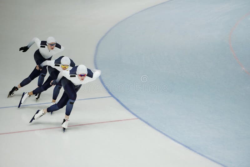 Row of Three Young Active Athletes on Skates Sliding Along Ice Rink ...