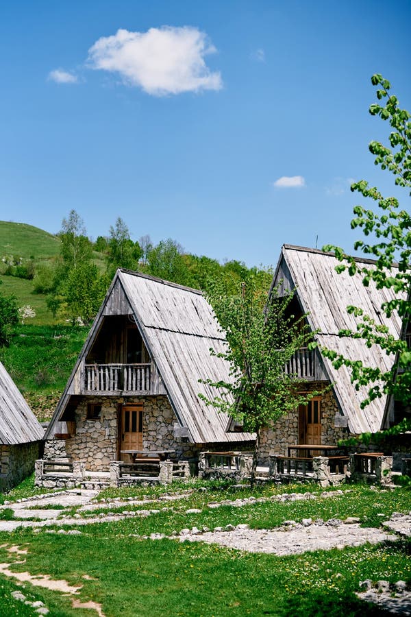 Row of Triangular Houses on a Green Plain at the Foot of a Hill Stock ...