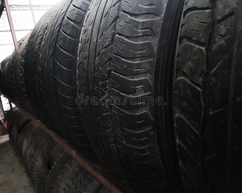 Row of Worn Tires on a Rack in the Garage Stock Image - Image of change ...