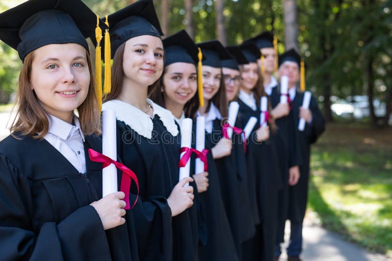 Row of Young People in Graduation Gowns Outdoors. Age Student. Stock ...