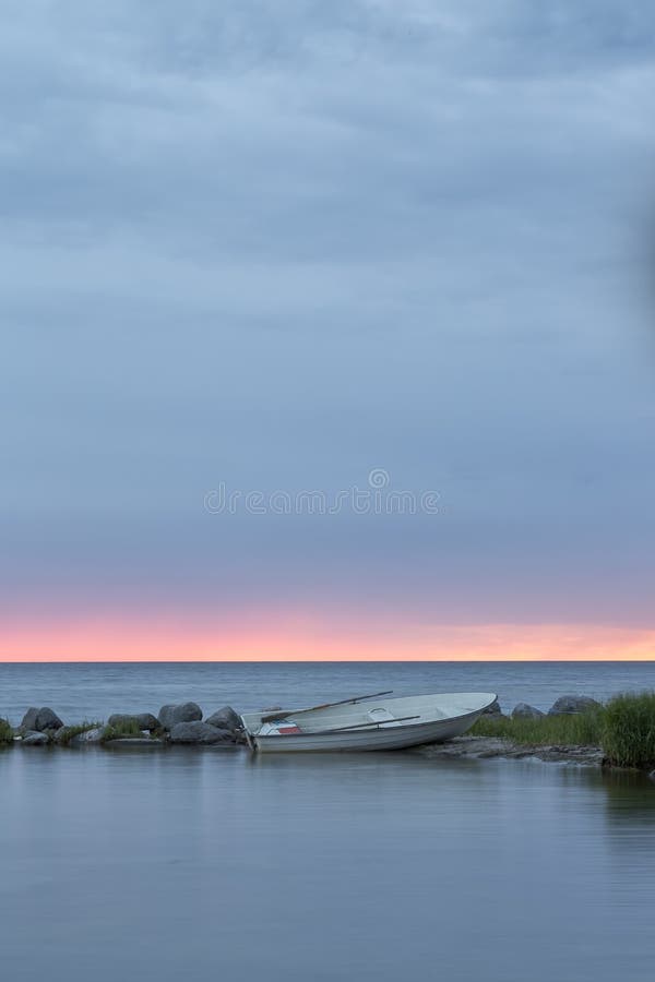 Rowboat by Ocean at Sunset stock photo. Image of sunset - 96740114