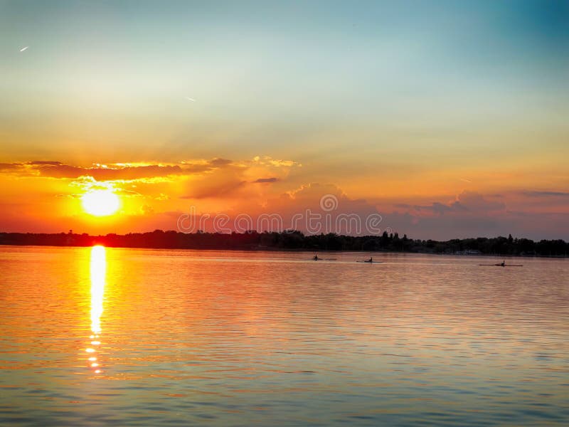 Rowing at the sunset stock photo. Image of stamina, lake - 124470194