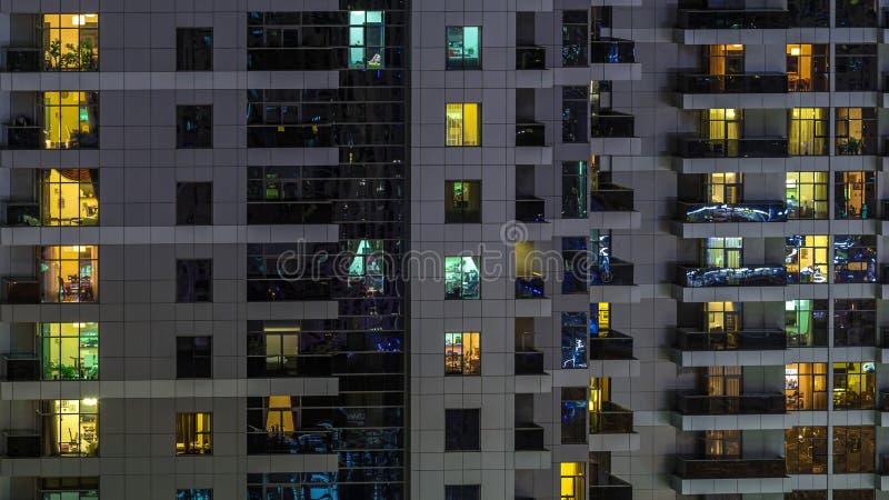 Rows of Glowing Windows with People in Apartment Building at Night ...