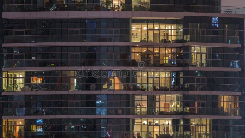 Rows of Glowing Windows with People in Apartment Building at Night ...