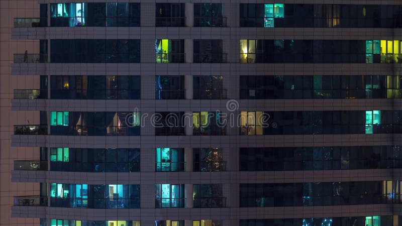 Rows of Glowing Windows with People in Apartment Building at Night ...