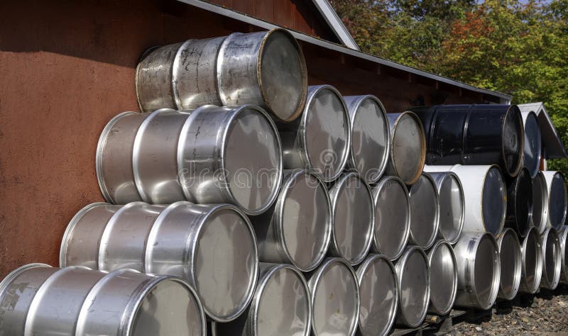 Rows of Stacked Metal Barrels Behind a Red Building Stock Photo - Image ...