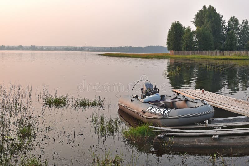 A Rubber Boat is Moored Off the Shore of a Calm Evening Lake Editorial ...