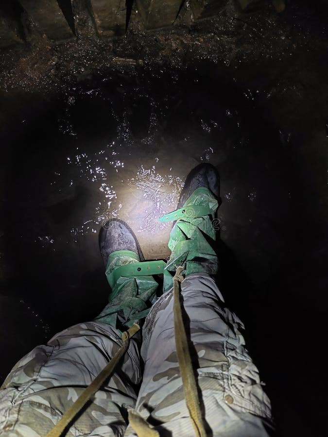 Rubber Boots of a Protective Suit and Camouflage Pants in the Light of ...