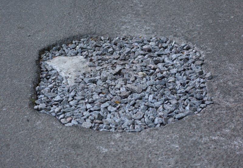 Rubble-covered Pothole in the Road Surface Stock Image - Image of road ...