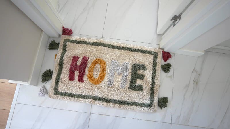A Rug with the Word Home Written on it is on the Floor in a Hallway ...
