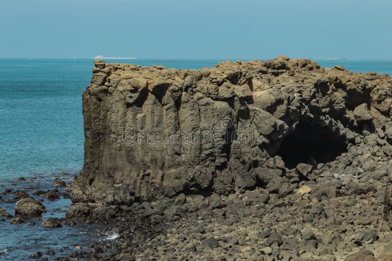Rugged Cave on the Precipice of a Cliff Overlooking a Tranquil Sea ...