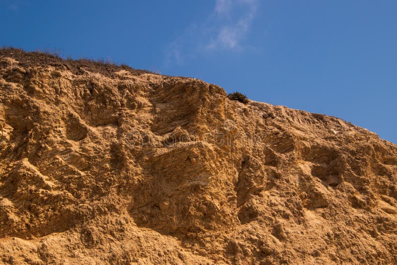 Rugged Jagged Brown Cliff Edge with a Seagull on a Ledge. Deep Blue Sky ...