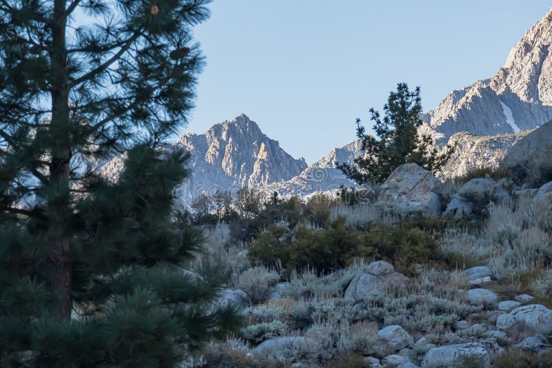 Rugged Mountain Peaks at Dawn Towering Over Hillside Stock Photo ...
