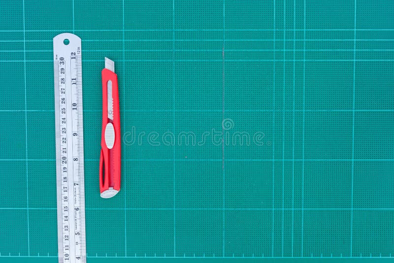A Ruler and Cutter on Green Cutting Mat Stock Photo - Image of ...