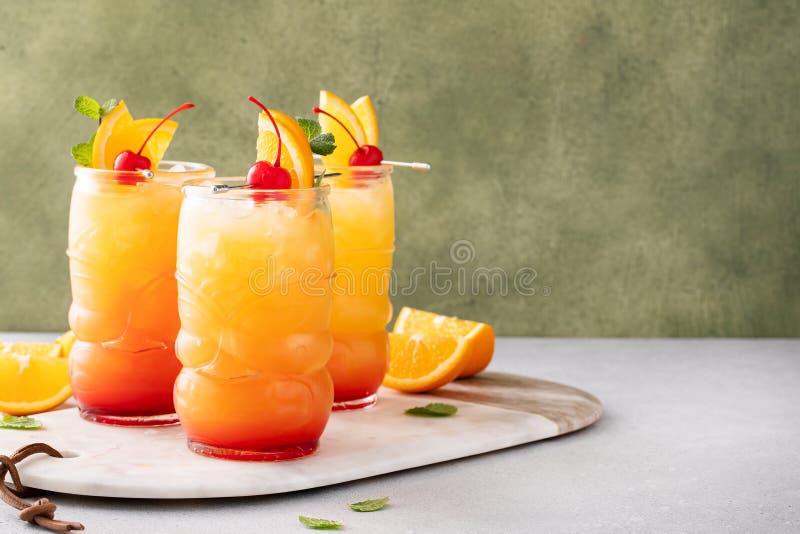 Rum Punch in Tiki Glasses with Orange Slices and a Cherry Stock Image ...