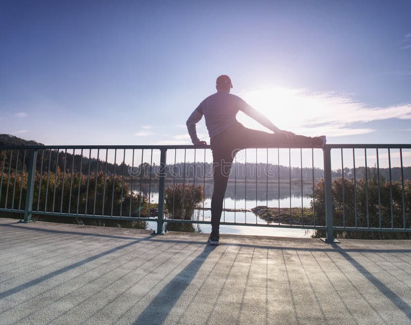 Runner Doing Stretching Exercise on Bridge. an Active Wiry Man Stock ...
