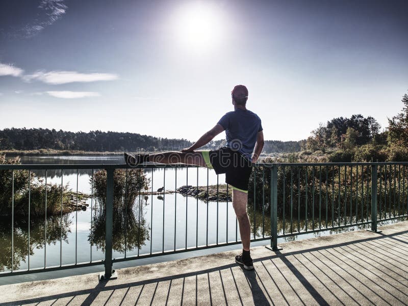 Runner Doing Stretching Exercise on Bridge. an Active Wiry Man Stock ...