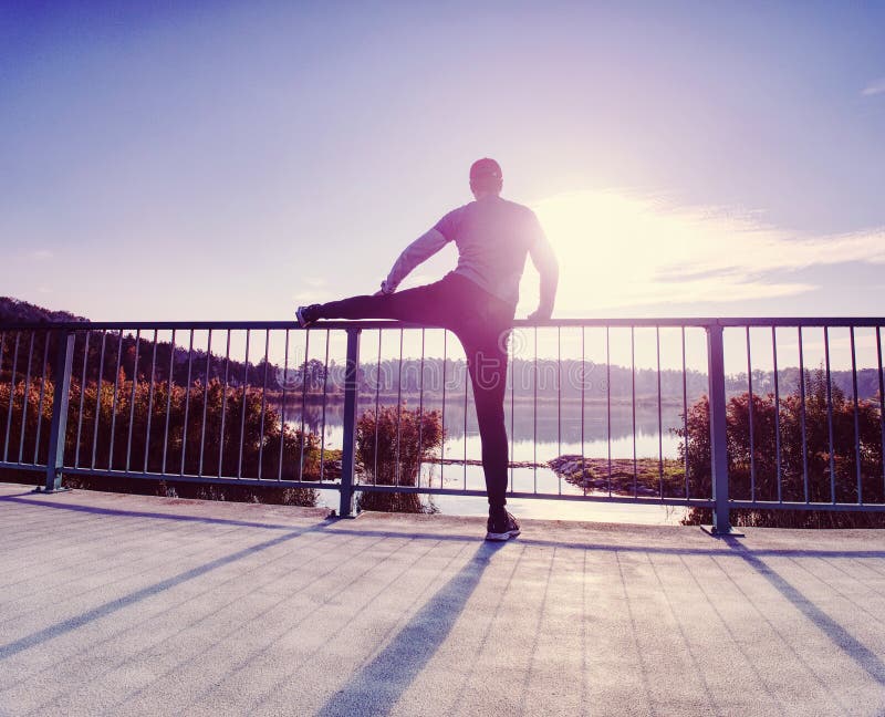 Runner Doing Stretching Exercise on Bridge. an Active Wiry Man Stock ...