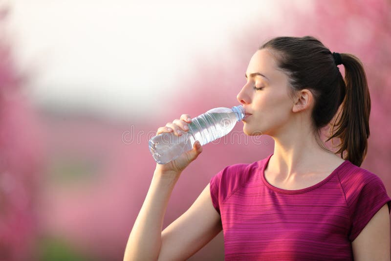 Runner Drinking Water from a Bottle in a Field Stock Photo - Image of ...