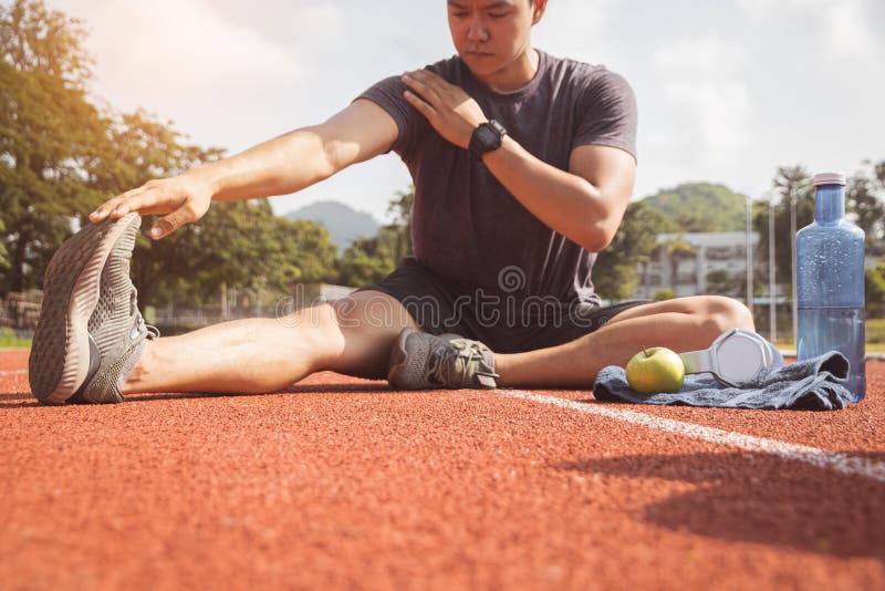 Runner Man is Stretching Legs Preparing for Run Training on Track Stock ...