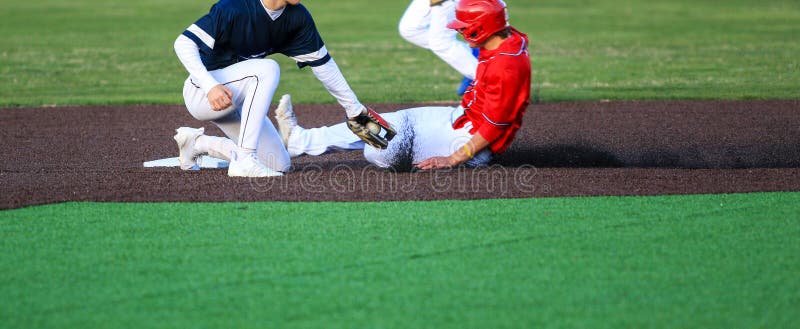 Runner Sliding into Second Base with the Short Stop Trying To Apply the ...